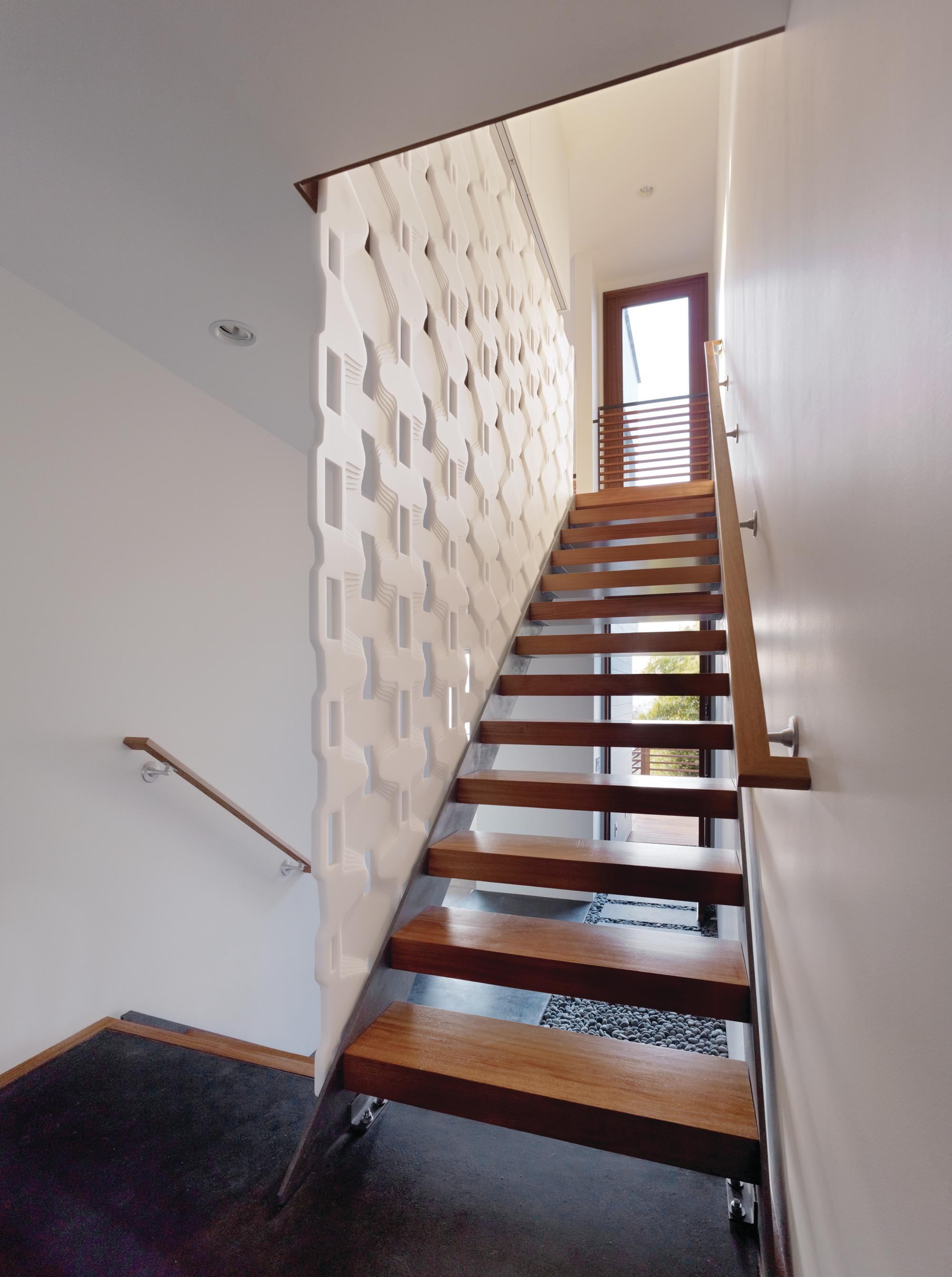 A laminated plexiglass screen along the stairs makes this entry hall ...